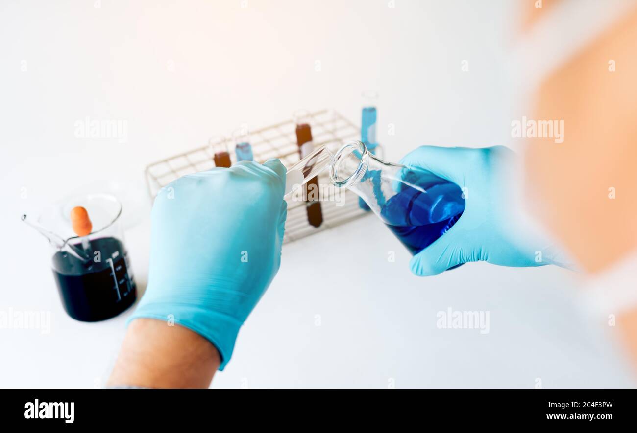 Scientific researcher or doctor pouring chemical substance test tube in ...
