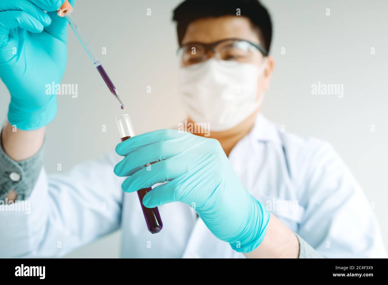 Chemist scientist conducts experiments by synthesising compounds with ...