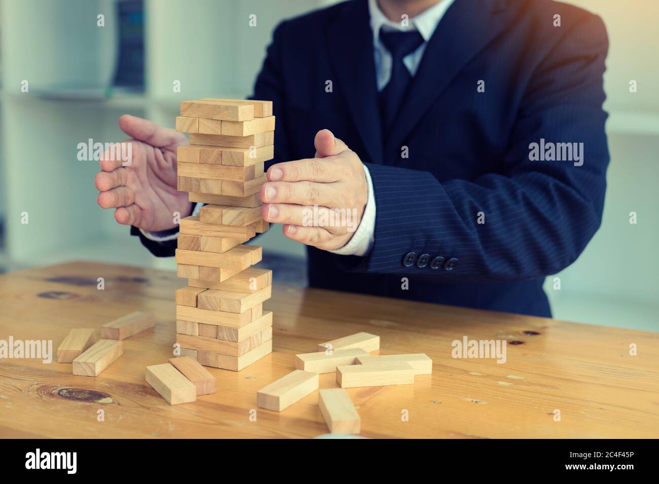 Hands of businessman protect block wooden on table with risk concept ...