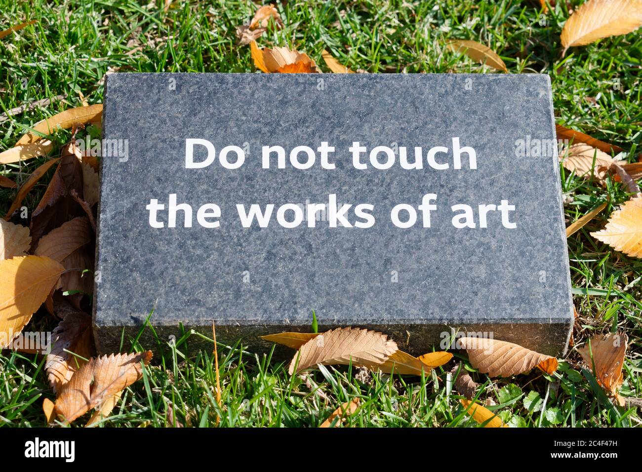 Rectangular granite slab with the text "Do not touch the works of art ...