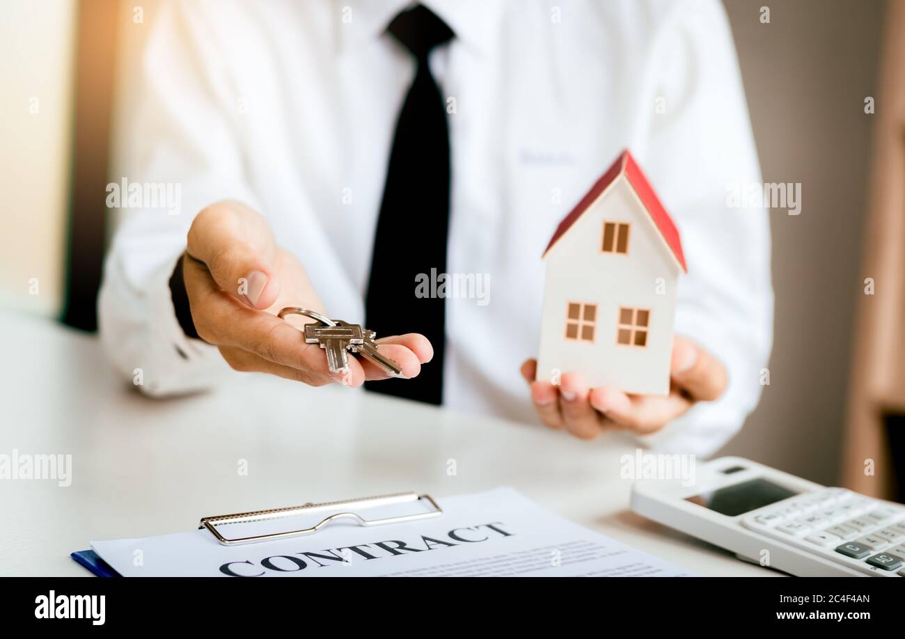 Real estate agent and giving key to client Stock Photo - Alamy