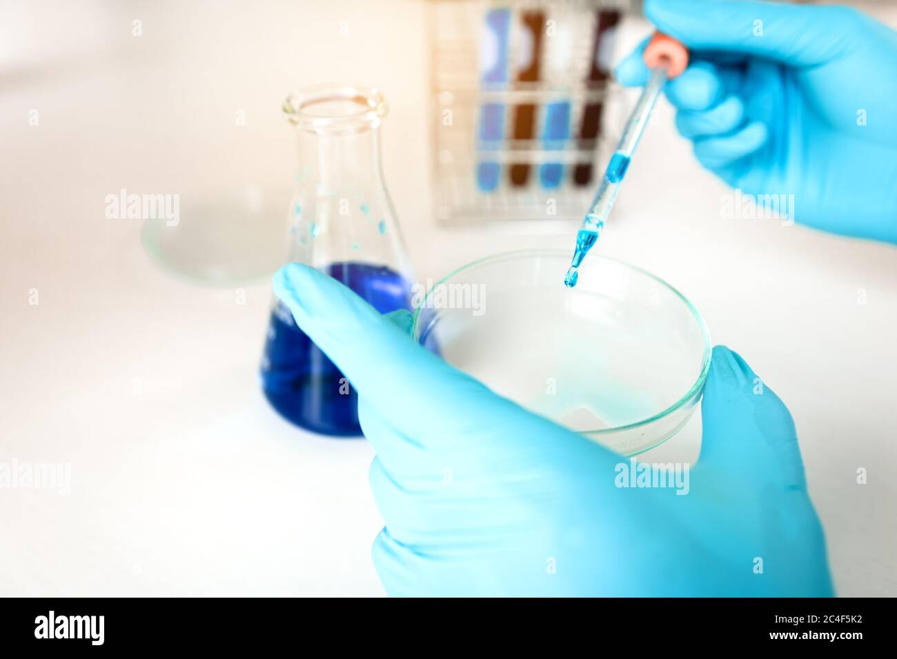 Science doing experiment in laboratory adding liquid in test tube with ...