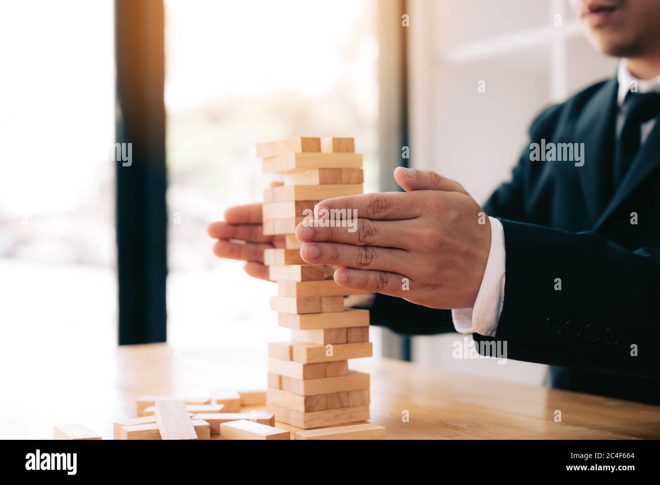Hands of businessman protect block wooden on table with risk concept ...