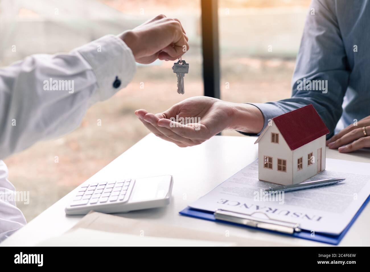 Salesman house brokers provide key to new homeowners in office Stock ...