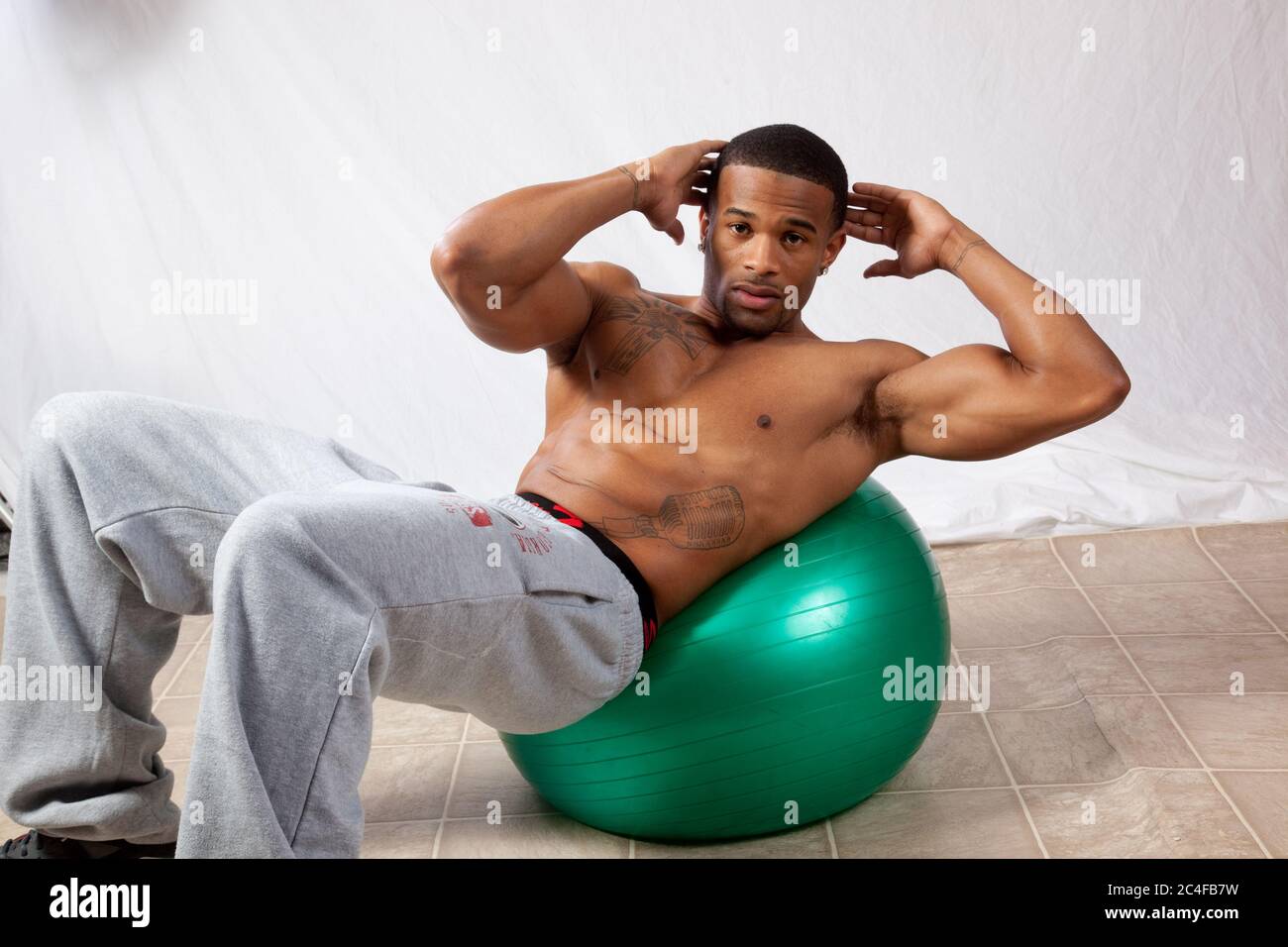 Strong Black man working out on an exercise ball Stock Photo - Alamy