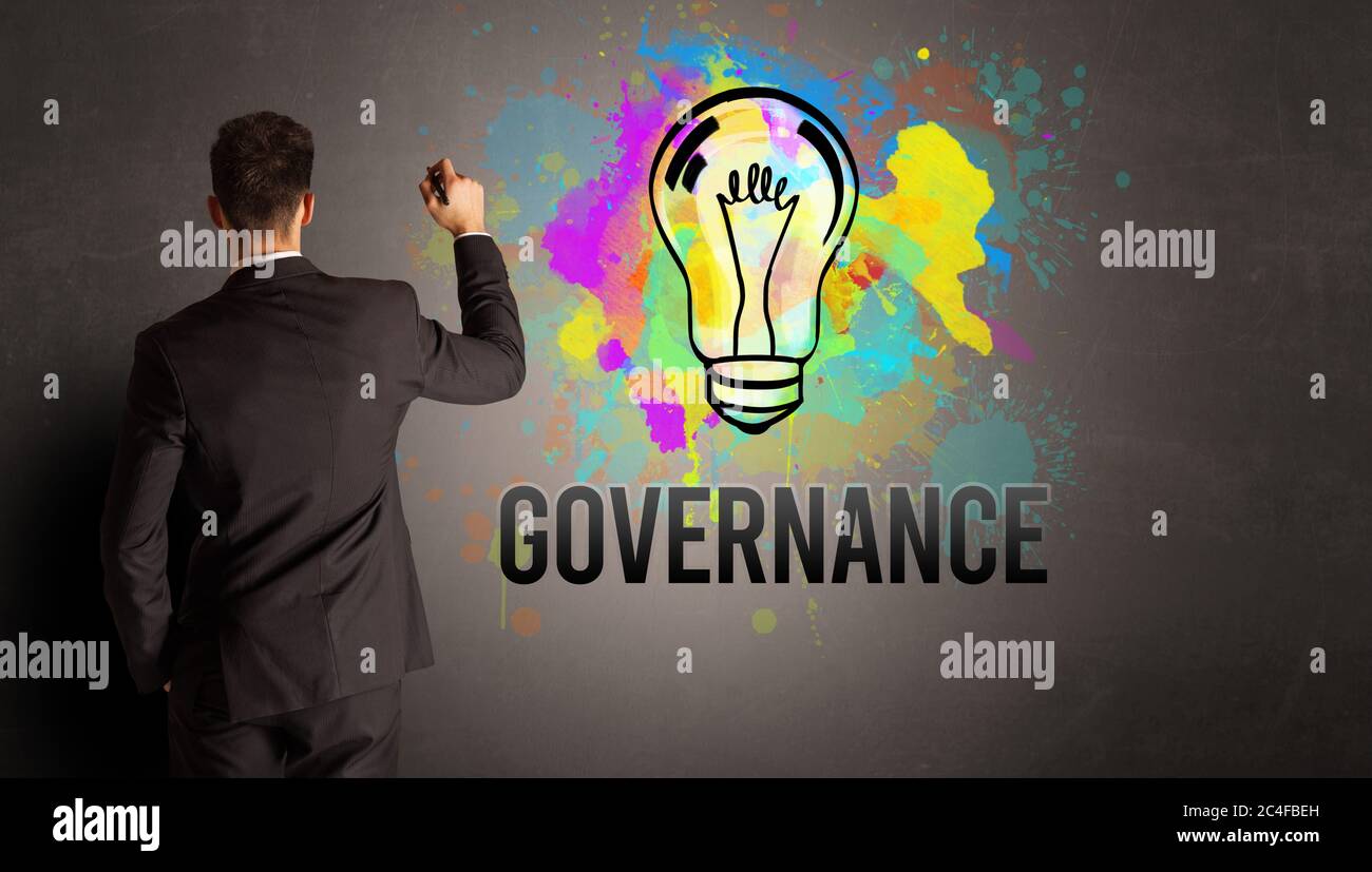 businessman drawing colorful light bulb with GOVERNANCE inscription on ...