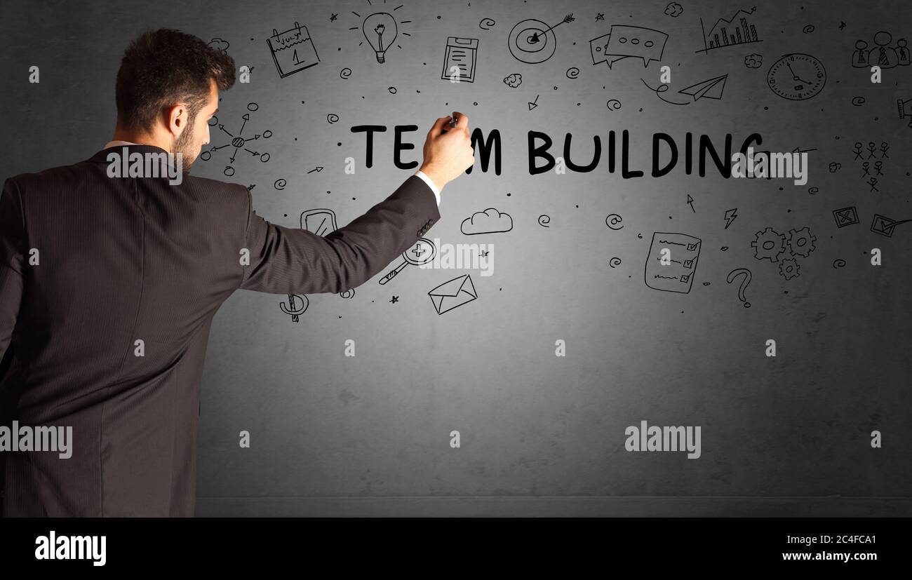 businessman drawing a creative idea sketch with TEAM BUILDING ...