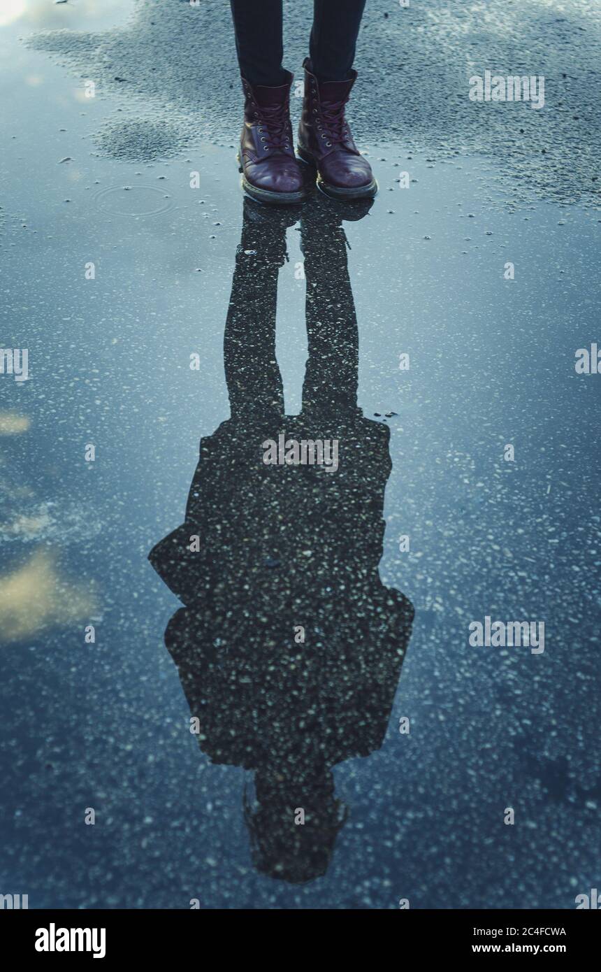 Young woman standing in rain puddle Stock Photo - Alamy