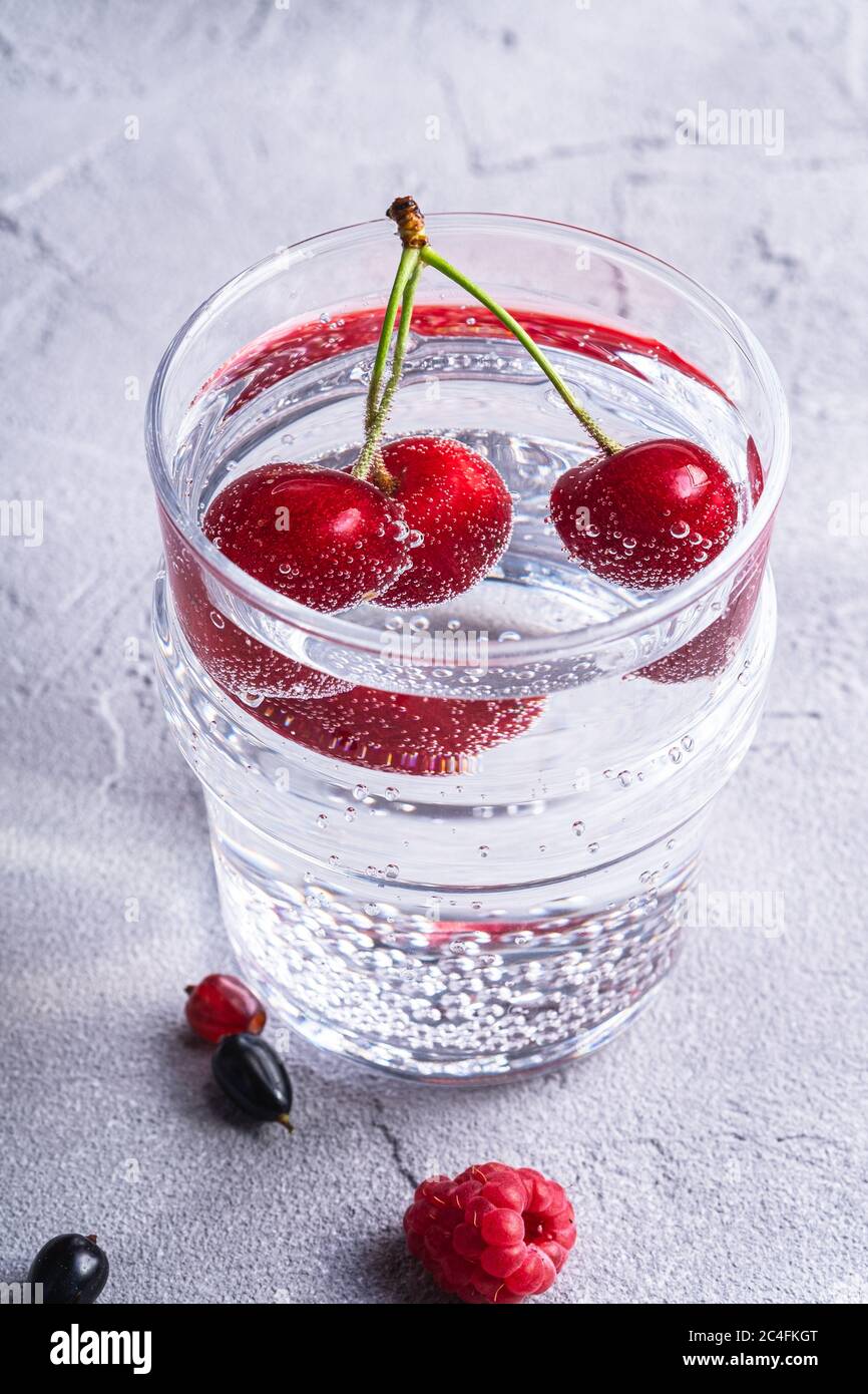 Fresh cold sparkling water drink with cherry, raspberry and currant ...