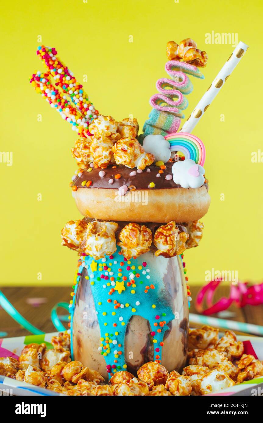 Chocolate freak shake topping with donut and caramel popcorn on yellow ...