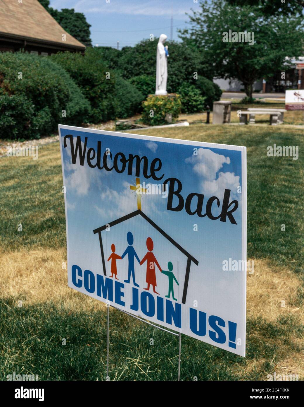 A lawn sign outside of a church reads Welcome Back Come Join Us. In the ...