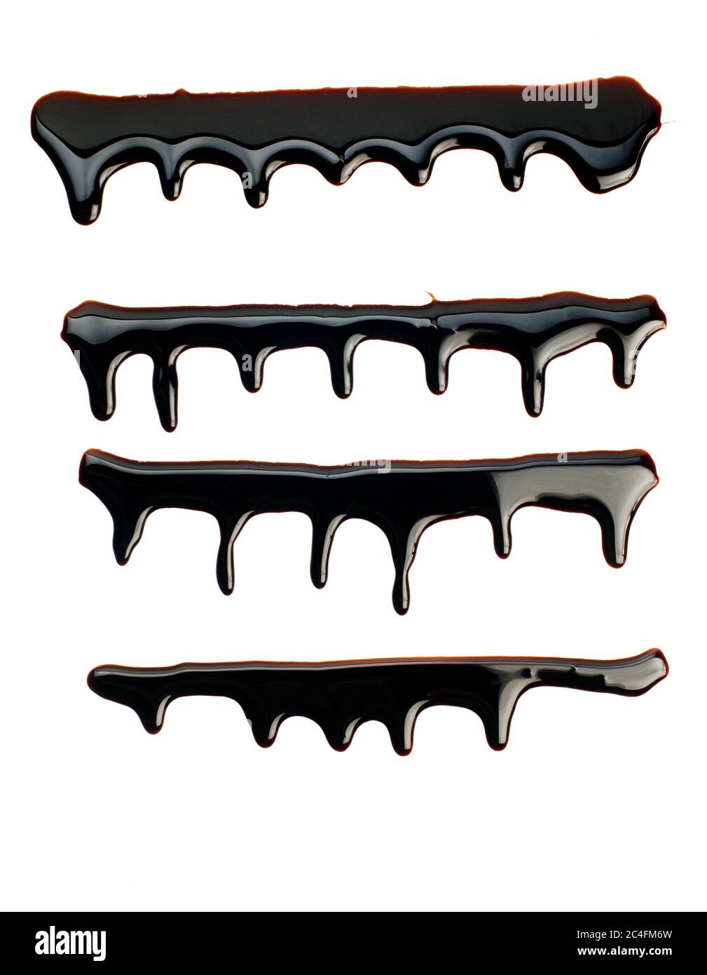 Different lines of melted dark chocolate isolated on white background ...