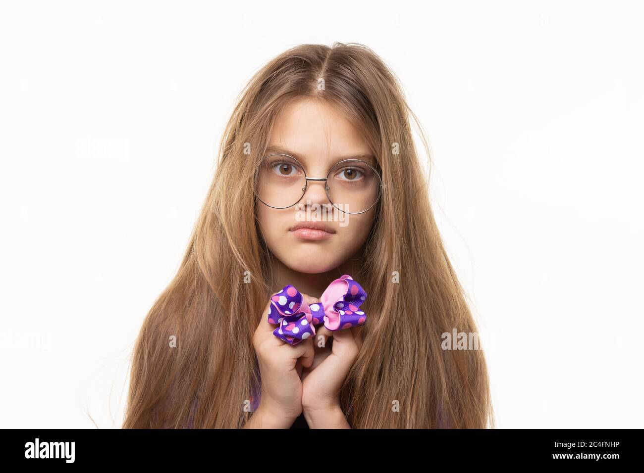 Closeup portrait of a scared girl with a blue bow in her hands Stock ...
