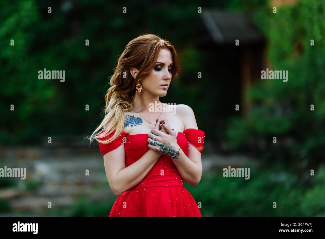 Redhead tattoed woman in red dress near the castle Stock Photo - Alamy