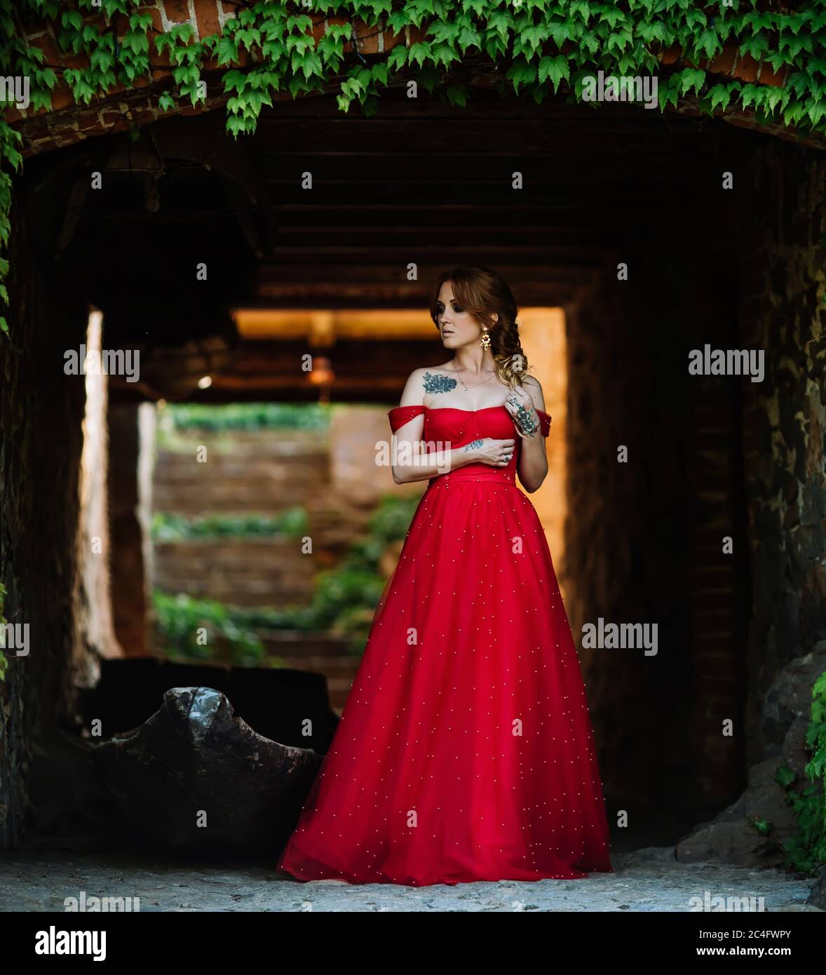 Redhead tattoed woman in red dress near the castle Stock Photo - Alamy