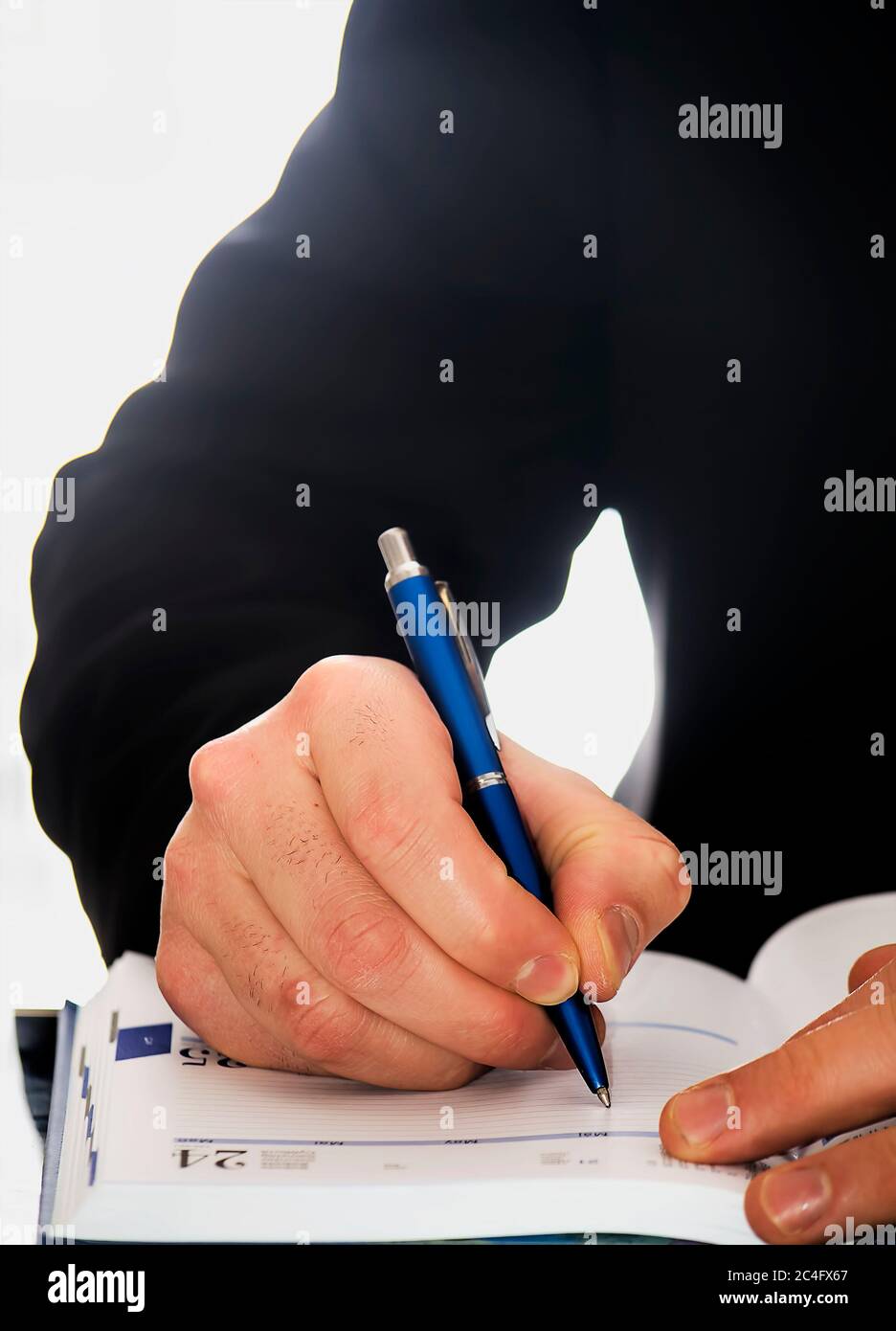 Closeup of a hand of a business man writing in a diary Stock Photo - Alamy
