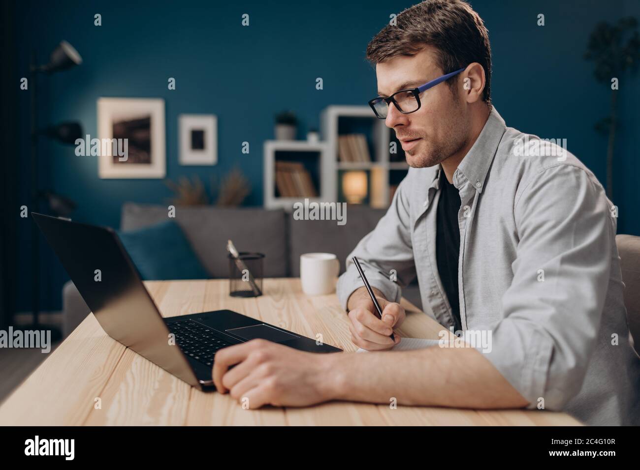 Man on computer making notes hi-res stock photography and images - Alamy