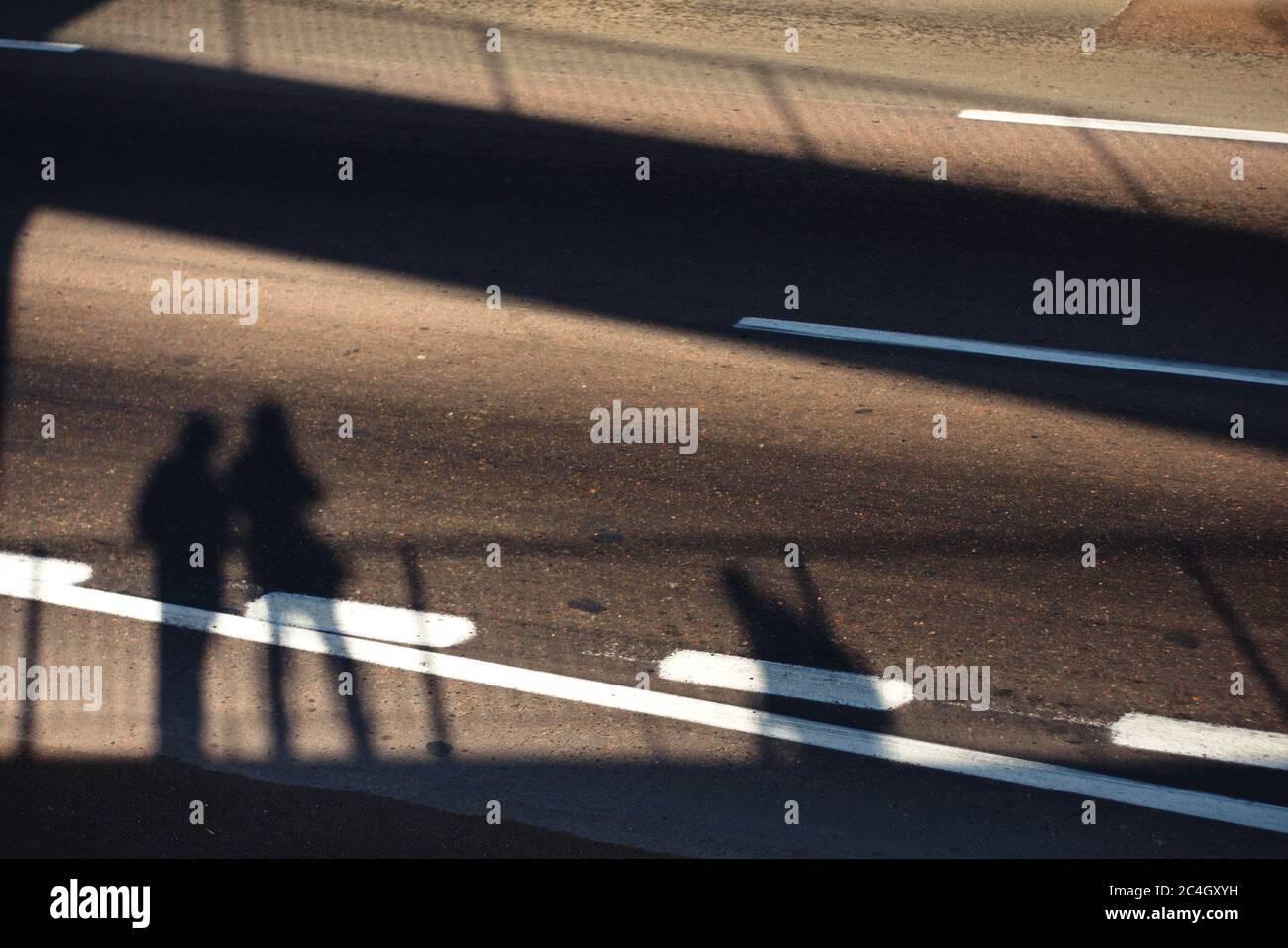 Shadows oif people on an elevated pedestrian pass projected on an empty ...