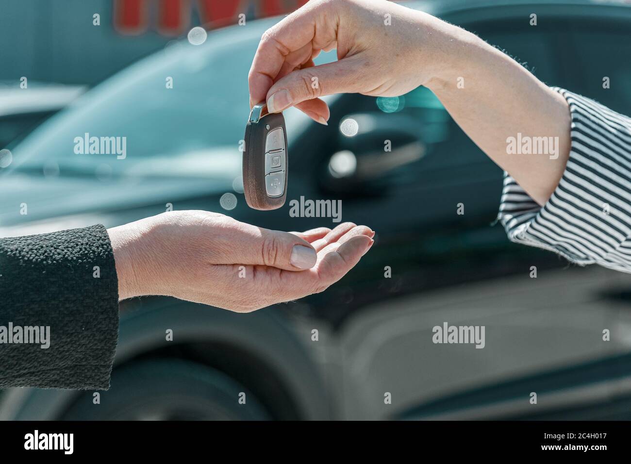 Seller delivers the keys to the customer. Business Woman giving a car ...