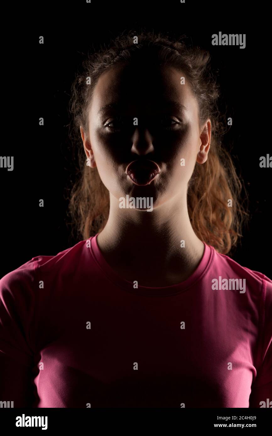 portrait of a girl with the face in shadow on a dark background Stock ...
