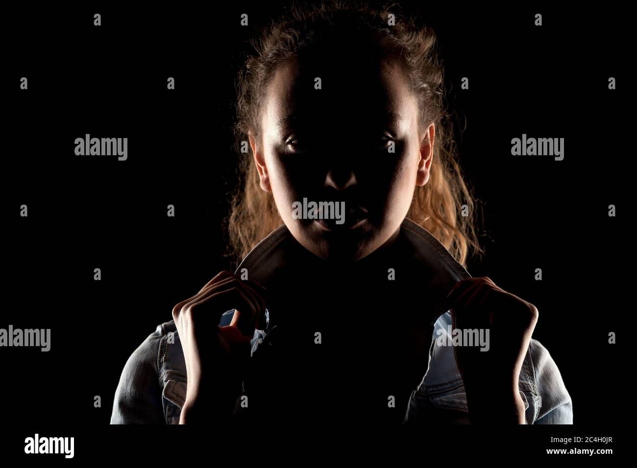 portrait of a girl with the face in shadow on a dark background Stock ...