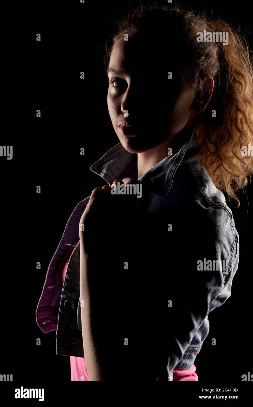 portrait of a girl with the face in shadow on a dark background Stock ...