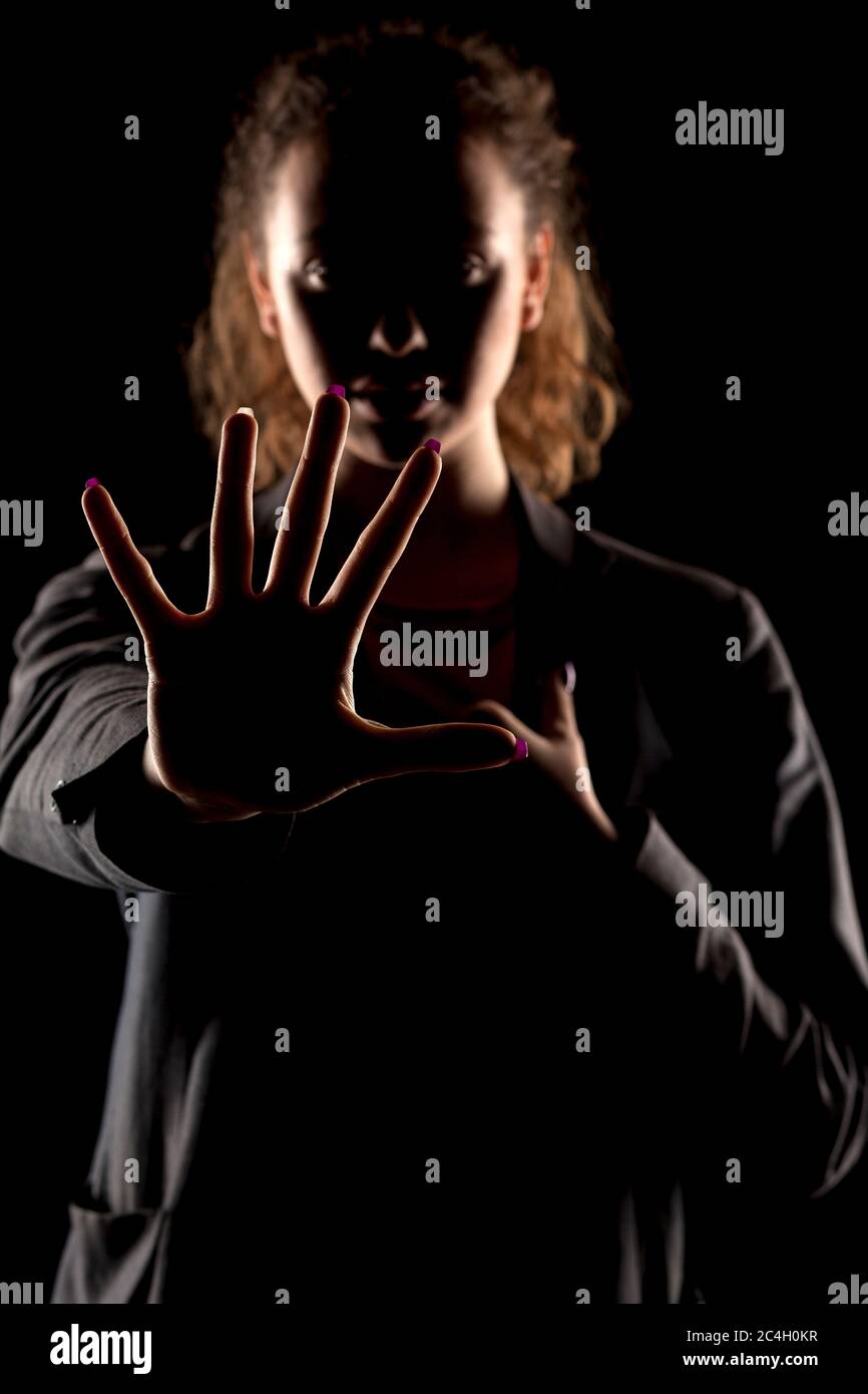 portrait of a girl with the face in a shadow showing stop hand Stock ...