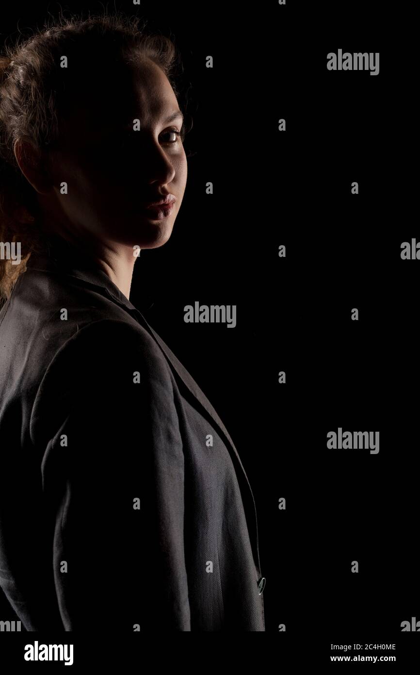 portrait of a girl with the face in shadow on a dark background Stock ...