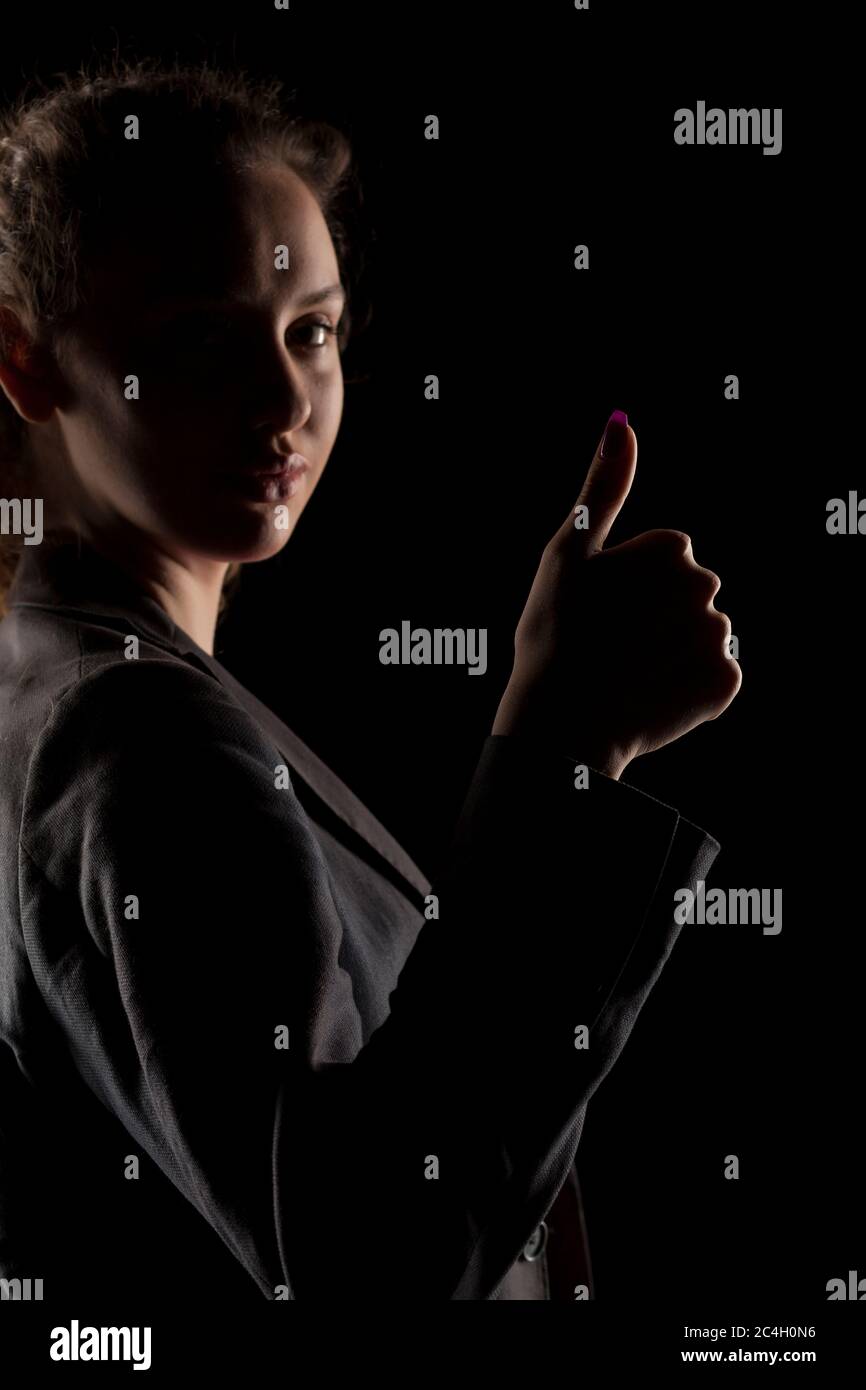 portrait of a girl with the face in shadow showing thumbs up Stock ...