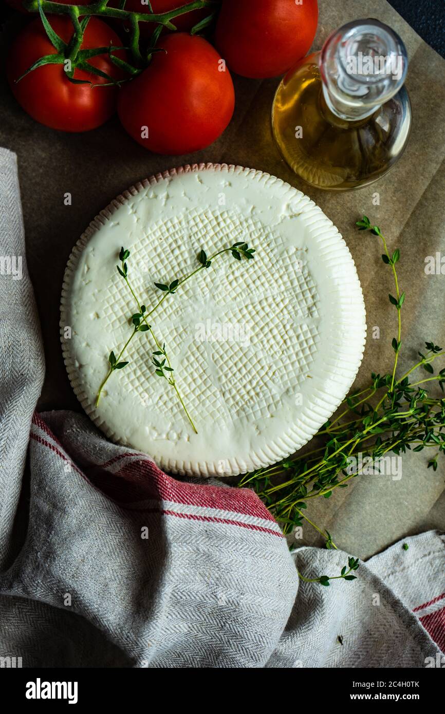 Georgian imeruli cheese with herbs, vegetable and oil on rustic ...