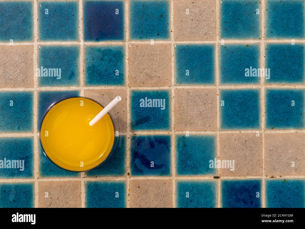 A glass of fresh orange juice for a refreshment on swiwming pool ...