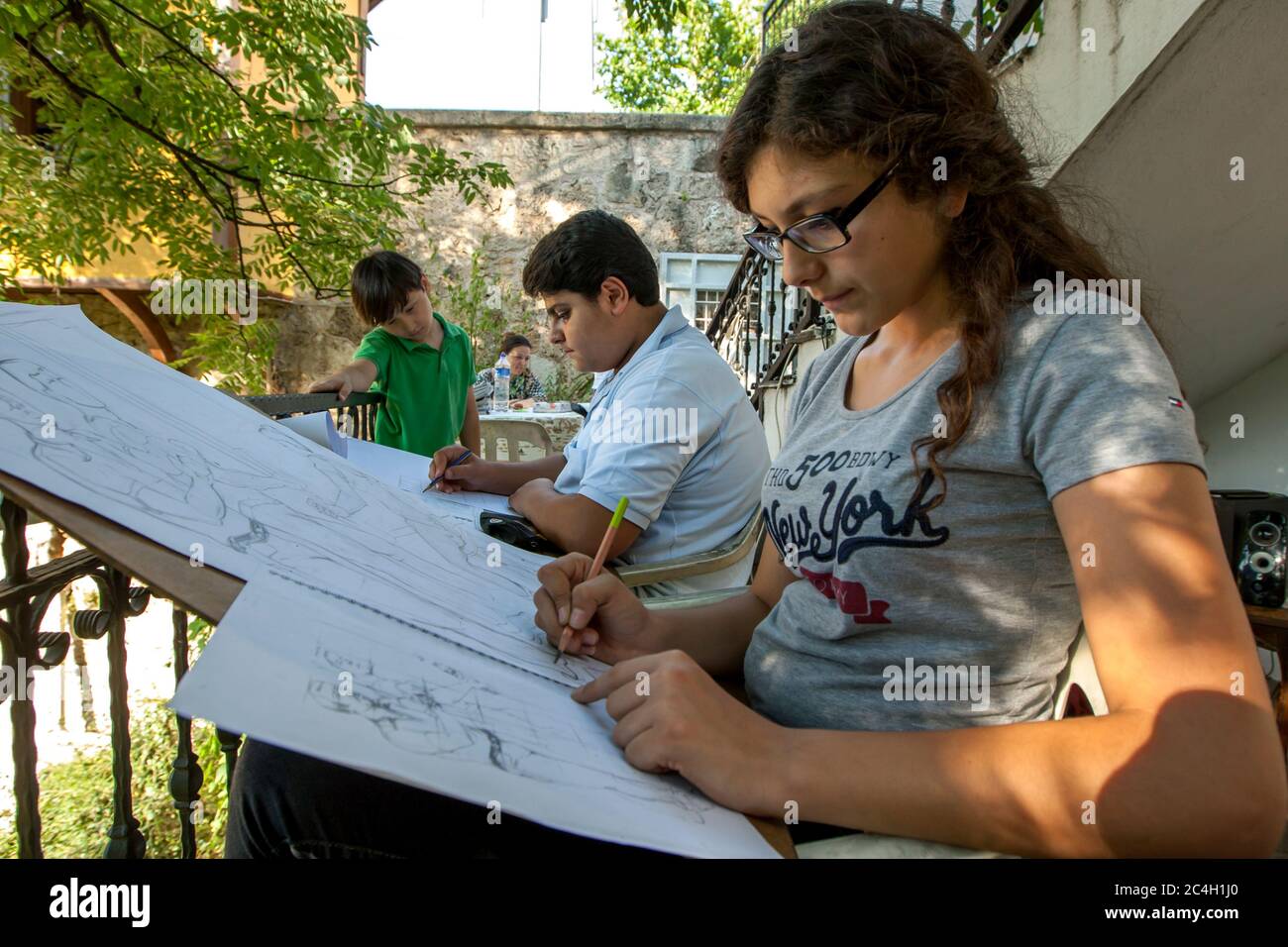Turkish students using pencils draw human figures during an art class ...