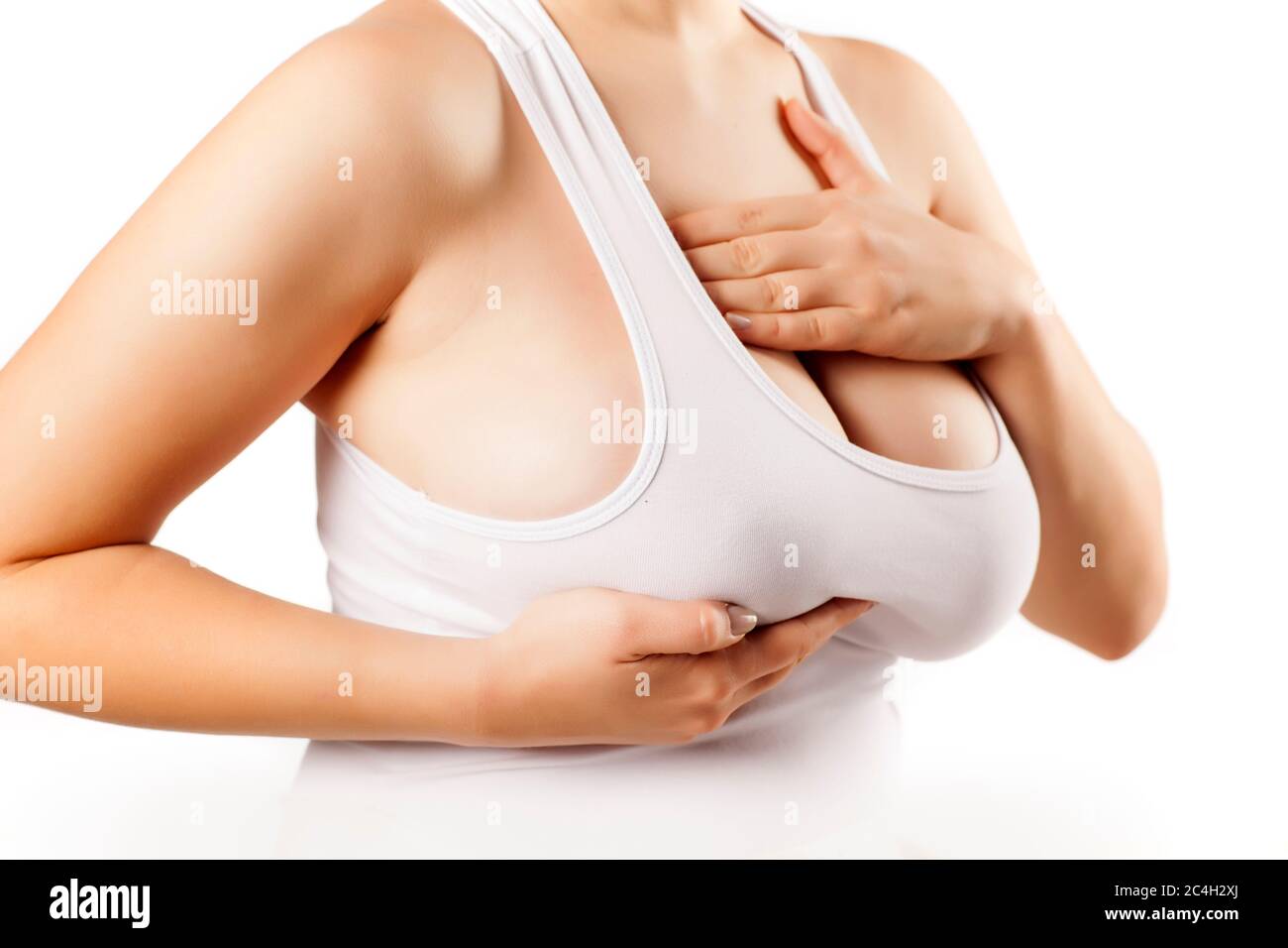 woman touching her breasts through the shirt on white background Stock Photo - Alamy