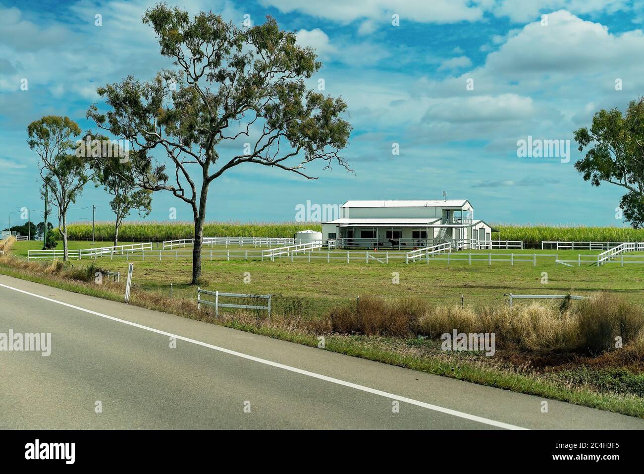 A country barn shape white homestead with horse paddocks Stock Photo ...