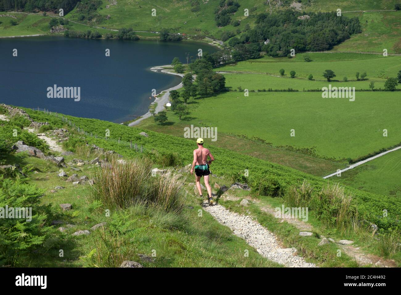 Fell runner descending towards Buttermere (lake) from Scarth Gap in the ...
