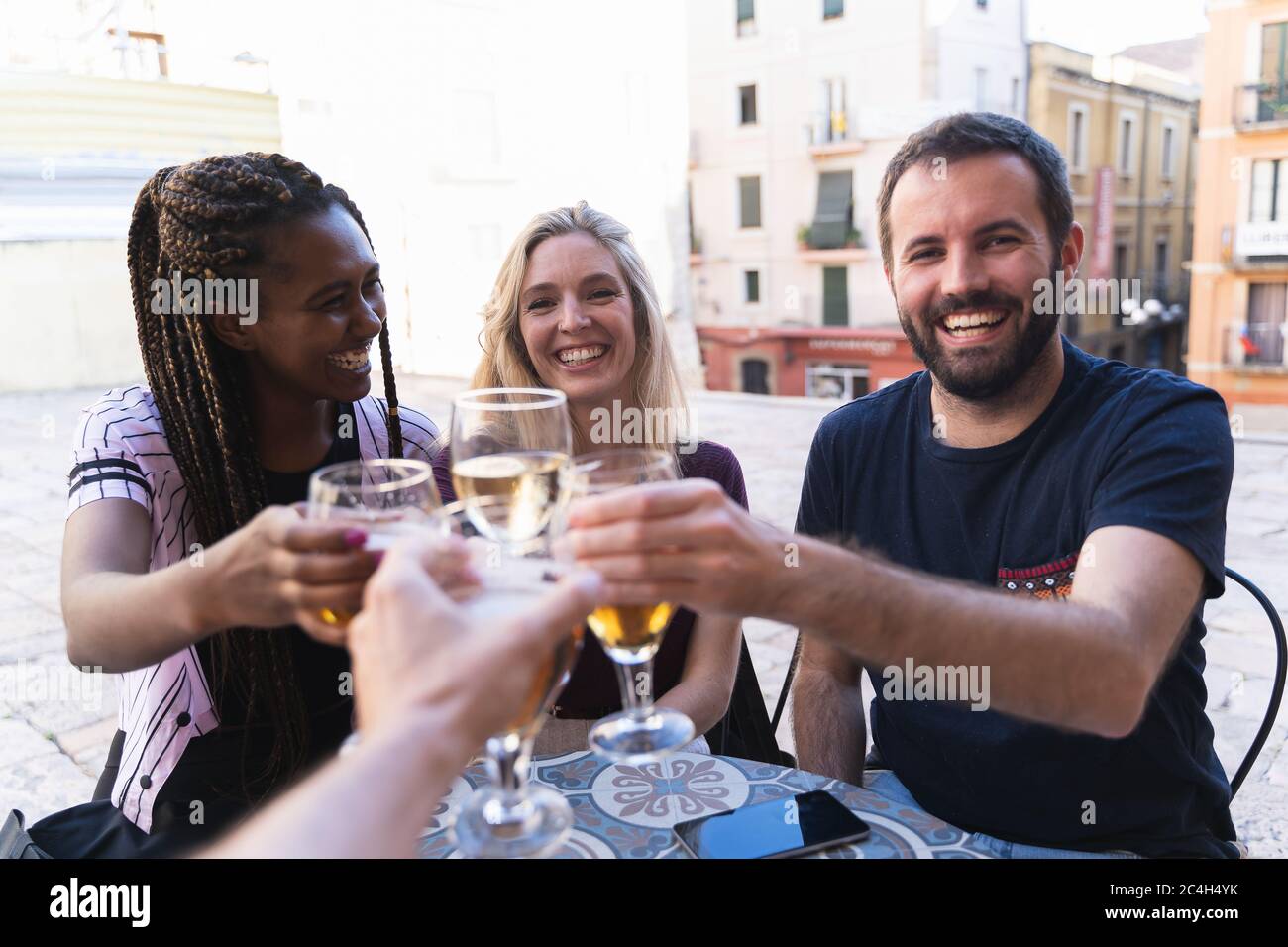 Friends drinking drinks on the terrace of a bar. The camera toasts with ...