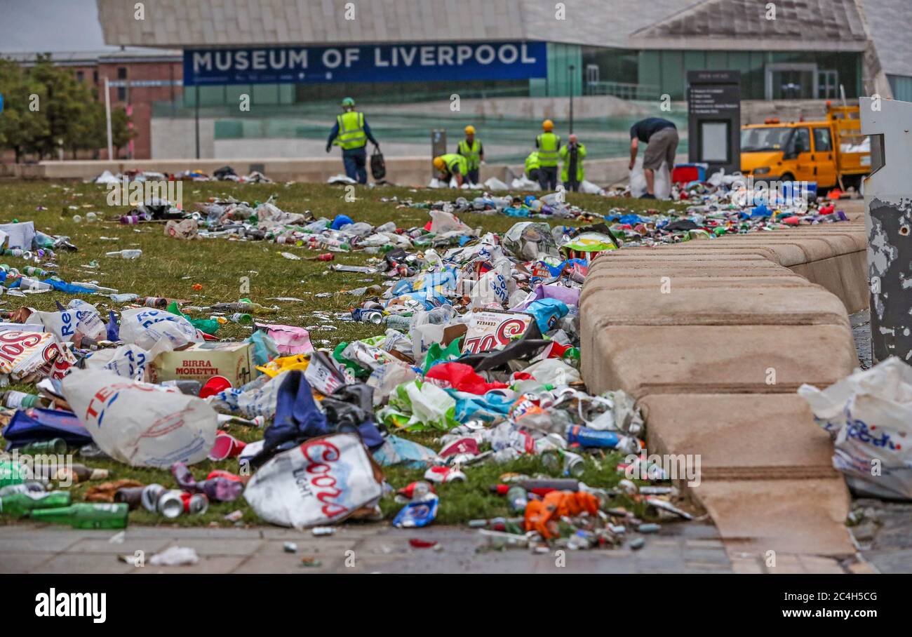 Workmen clear up rubbish left outside the Liver building in Liverpool ...