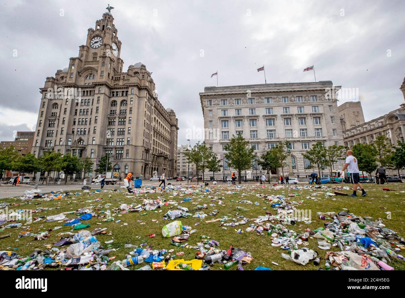 Workmen clear up rubbish left outside the Liver building in Liverpool ...