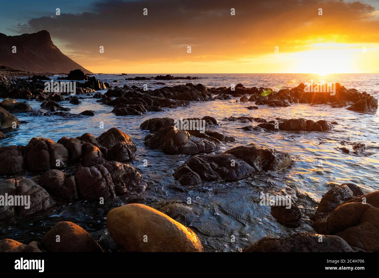 Sunset at False Bay (South Africa) with clouds and boulders on the ...