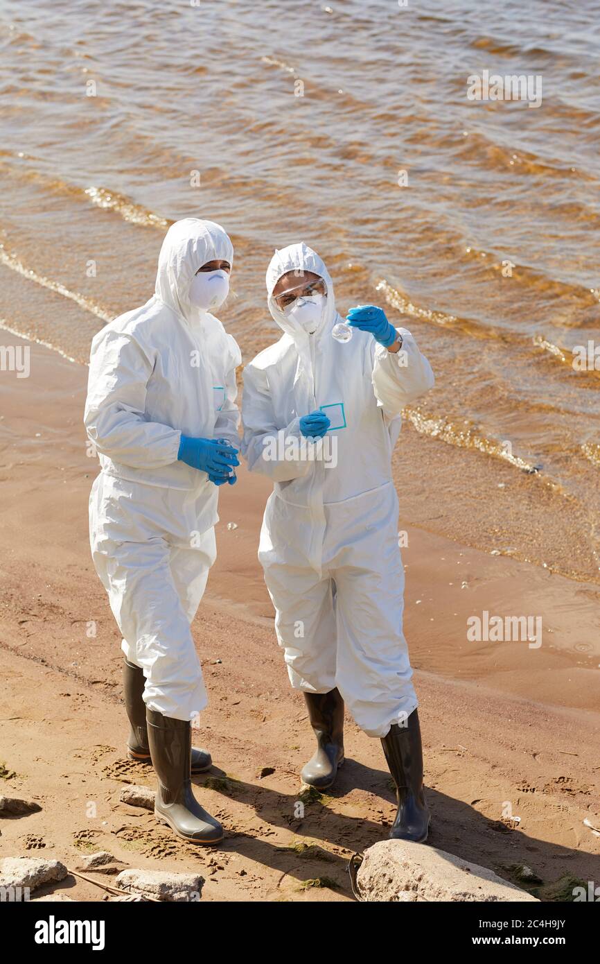 Ecologists in protective suits working in team they standing near the ...