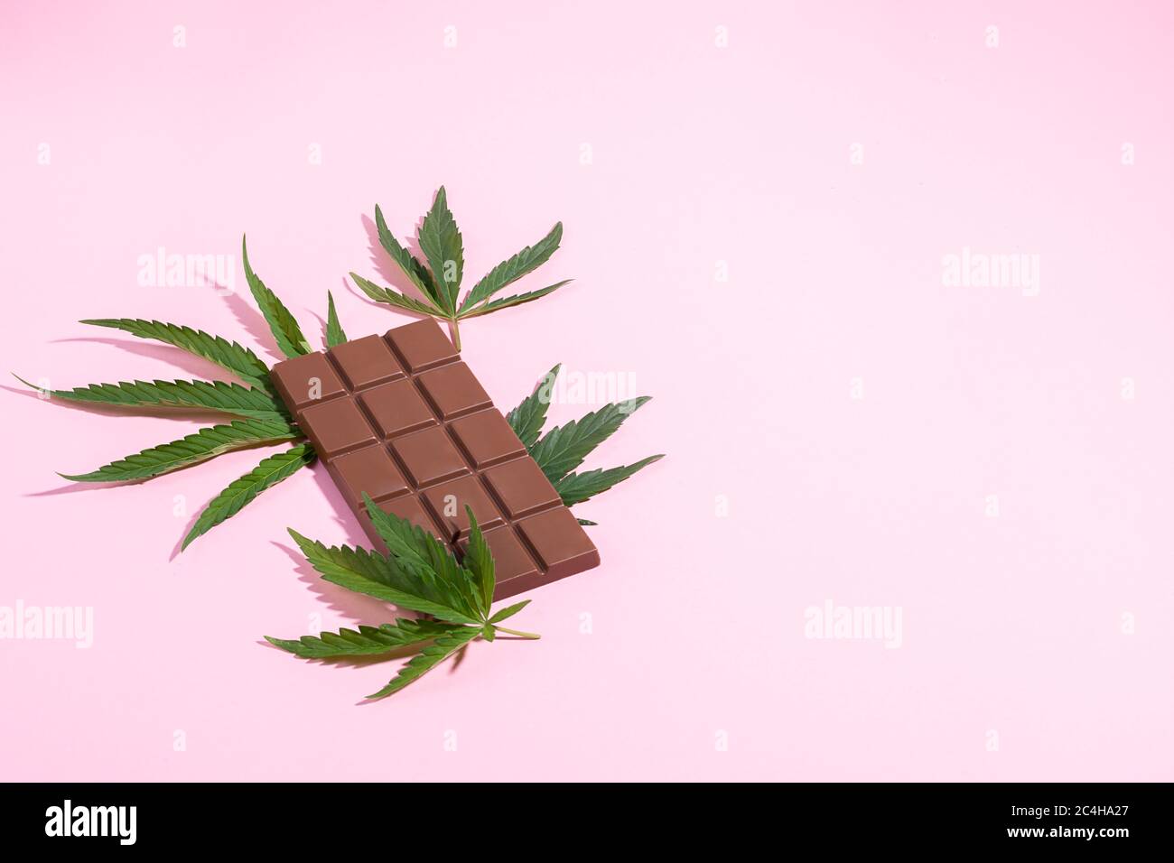 Dark chocolate and cannabis cannabis leaf on pink background ...