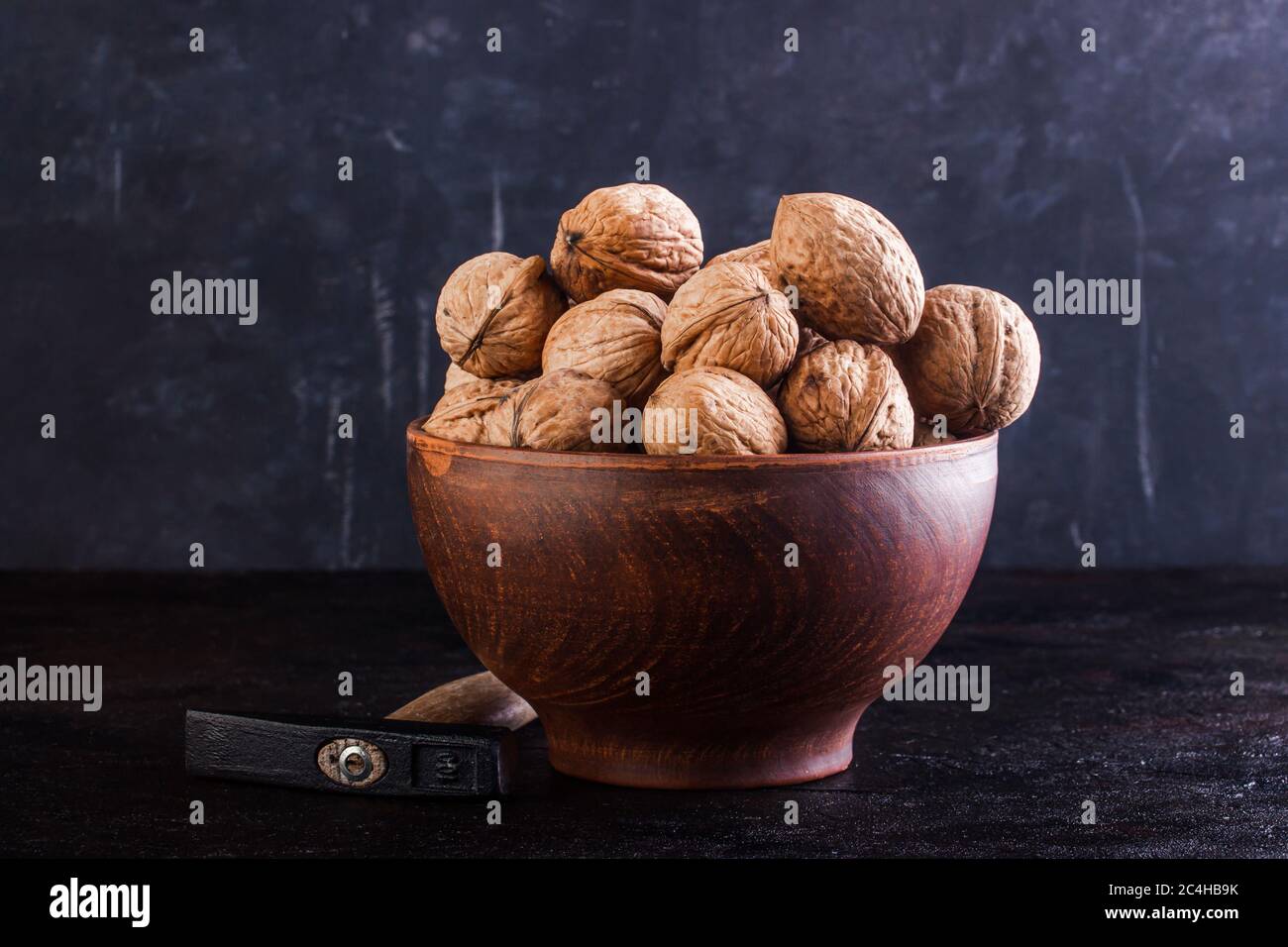 Walnut in a clay bowl and a gout on a concrete background Stock Photo ...