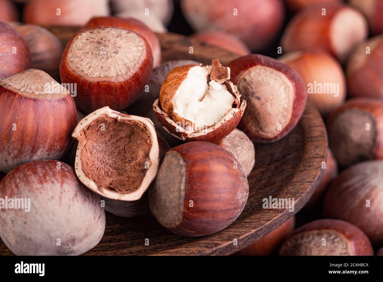 Hazelnuts in a spoon and one broken nut Stock Photo - Alamy