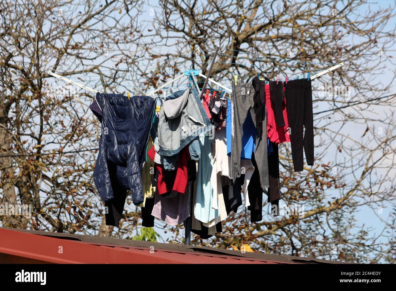 Various winter clothes from pants to jackets in various colors drying ...