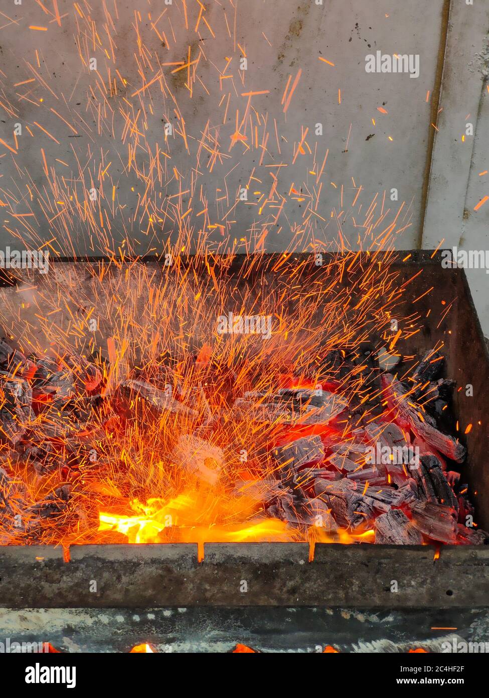 BBQ on fire with burning charcoal in brazier and flying sparks Stock ...