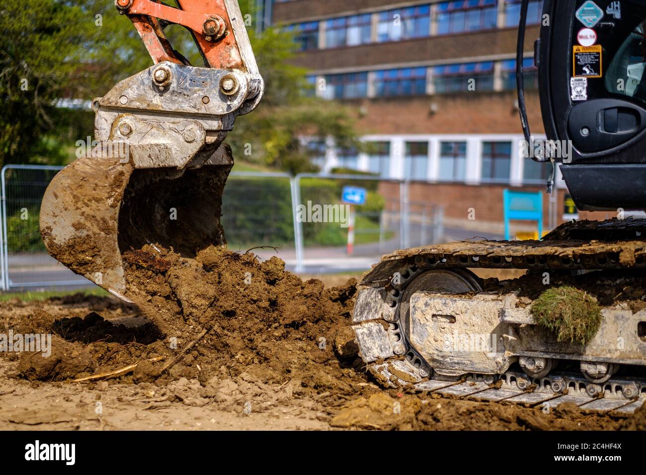Excavator bucket moves earth on construction site Stock Photo - Alamy
