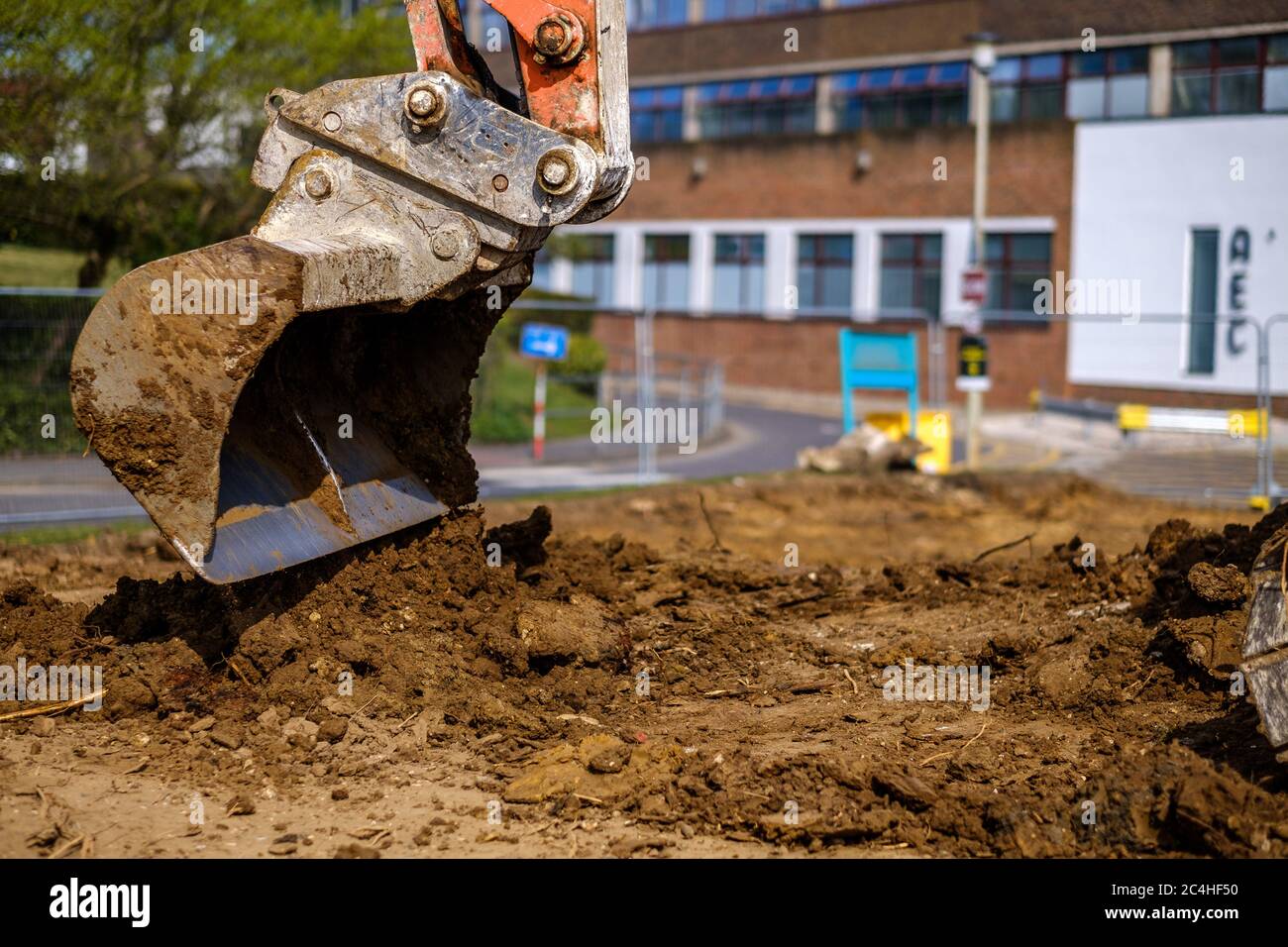 Excavator bucket moves earth on construction site Stock Photo - Alamy