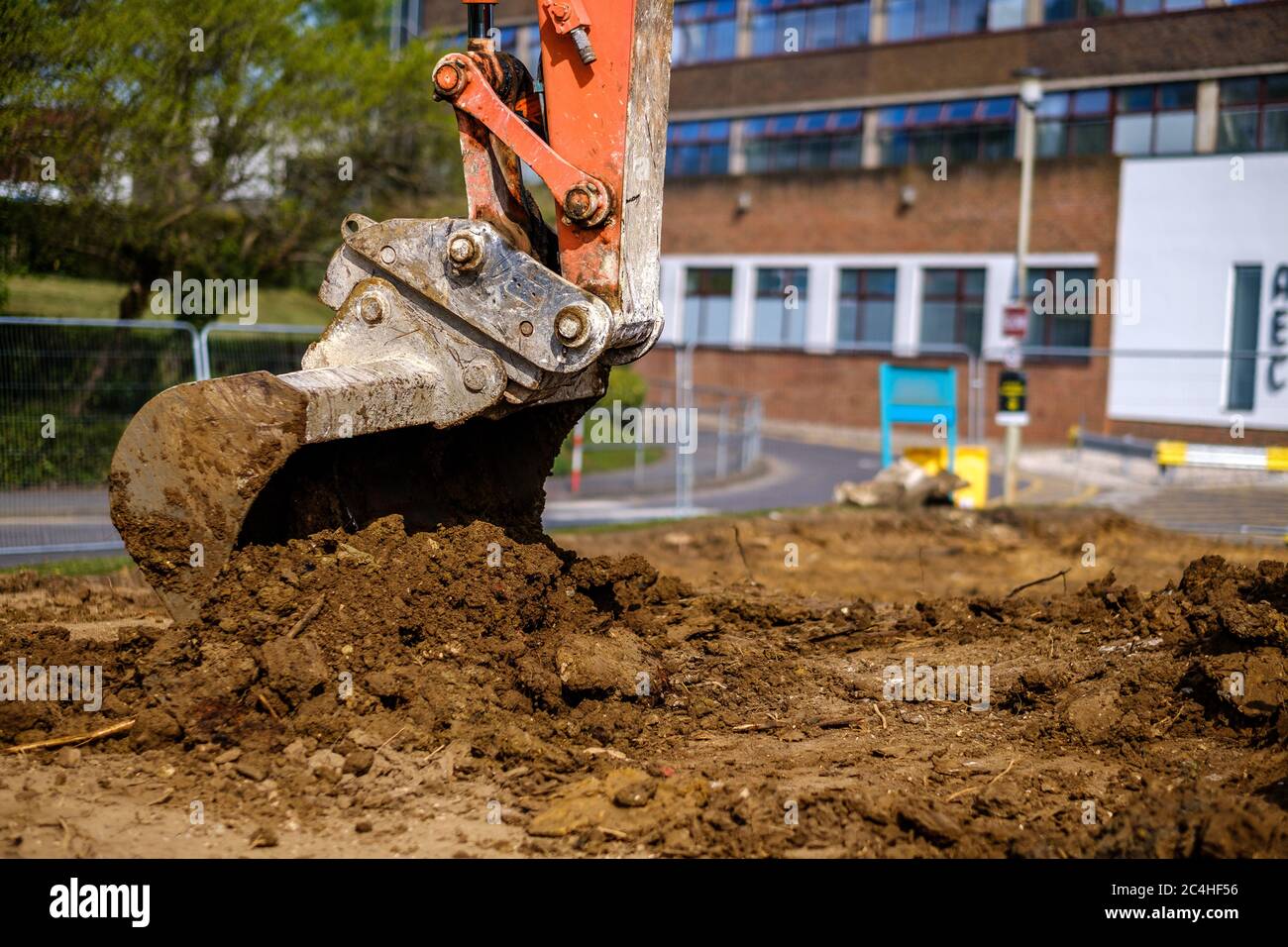 Excavator bucket moves earth on construction site Stock Photo - Alamy