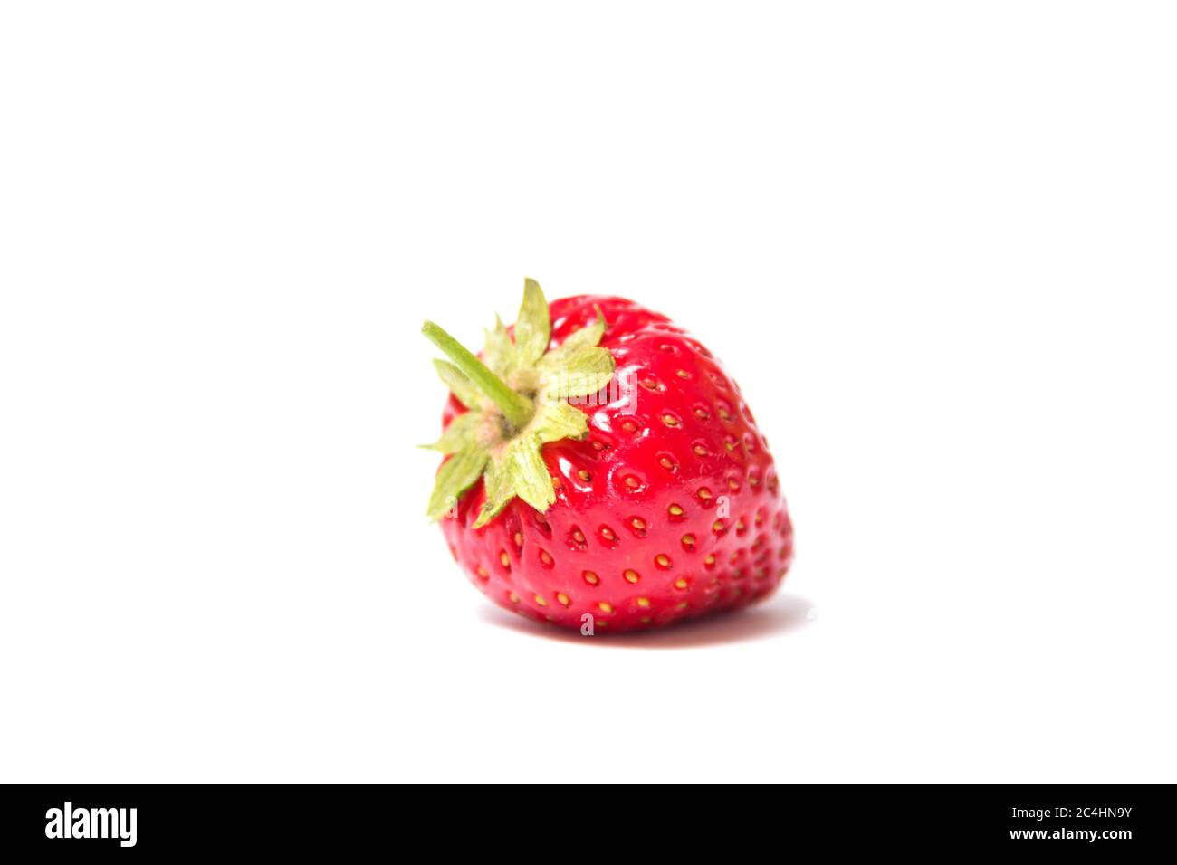 Red and ripe strawberry lies on its side on a white background ...