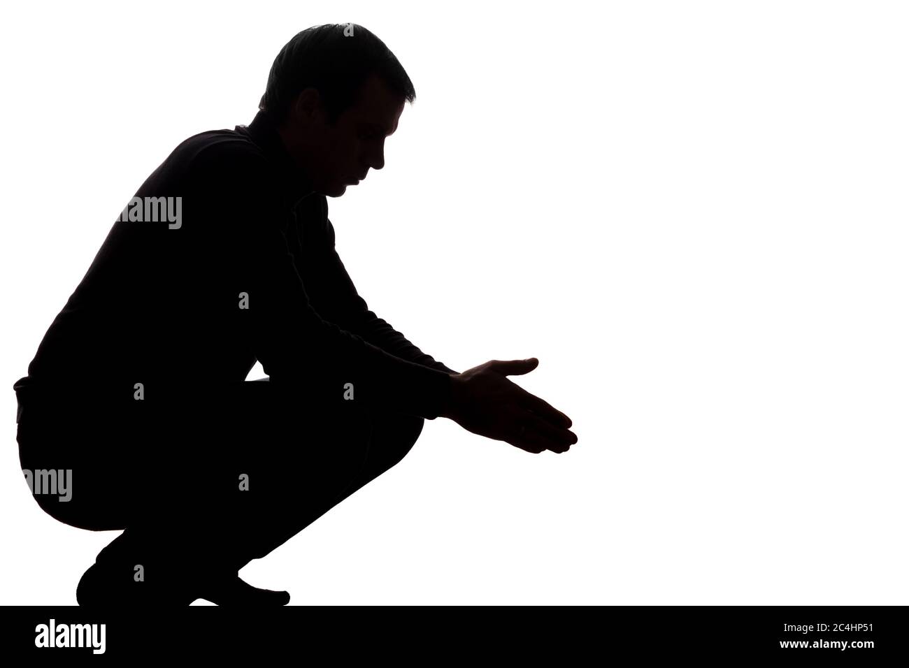 Portrait of a young man squatted down, side view - silhouette Stock ...